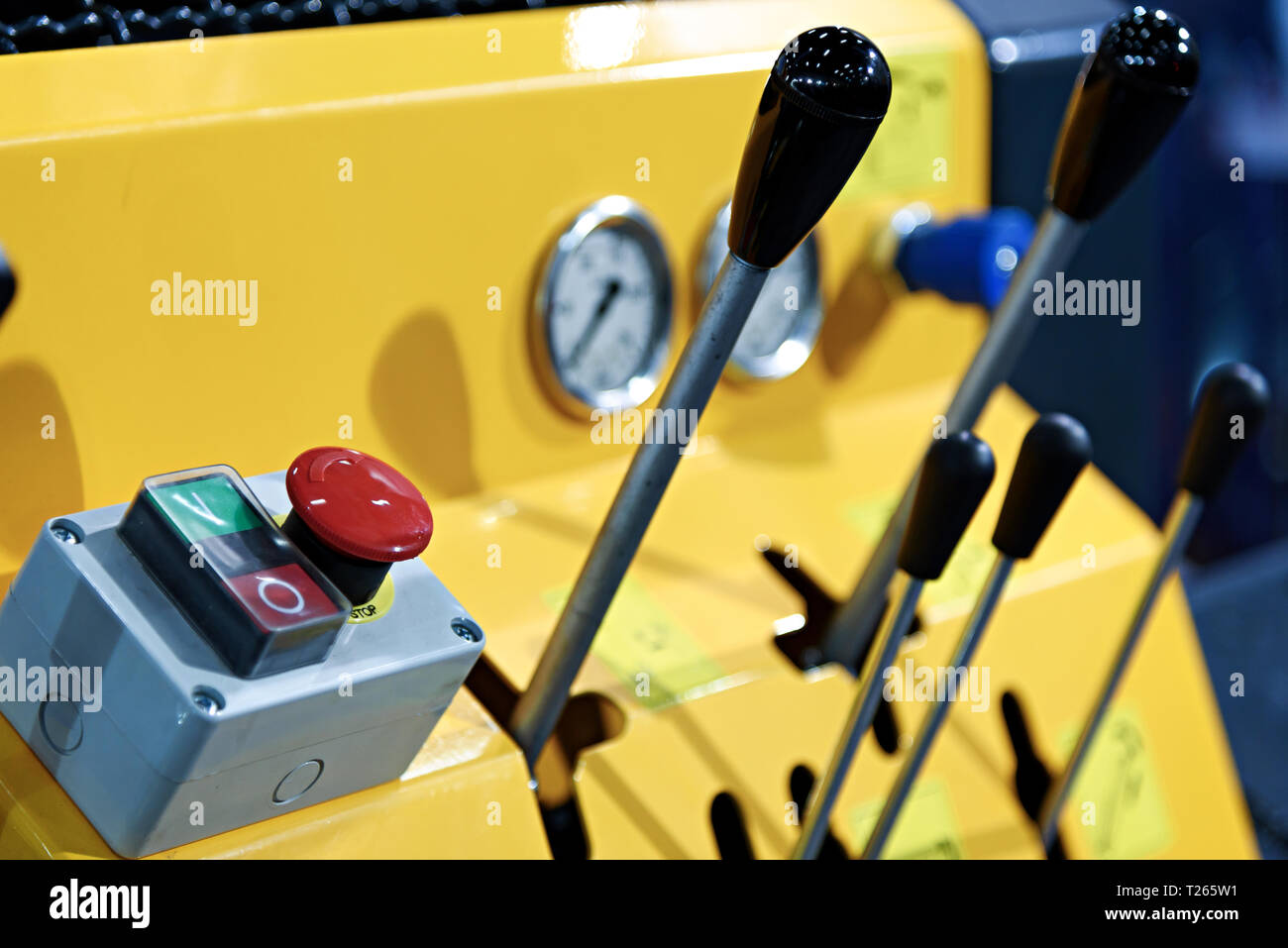 Close-up of a yellow control panel and security red stop button in the ...
