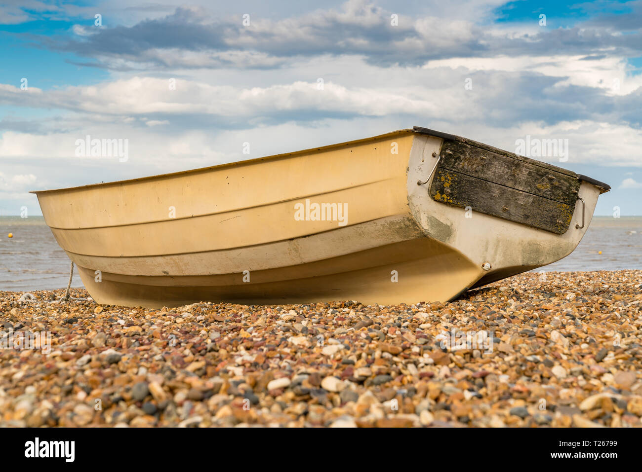 Clouds over a boat on the pebbles of Tankerton beach in Whitstable ...