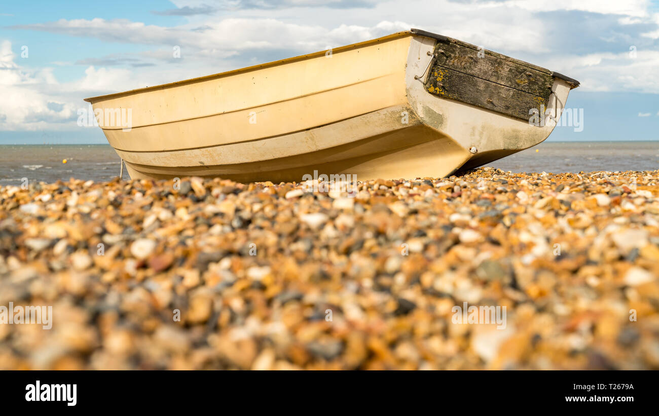 Clouds over a boat on the pebbles of Tankerton beach in Whitstable ...