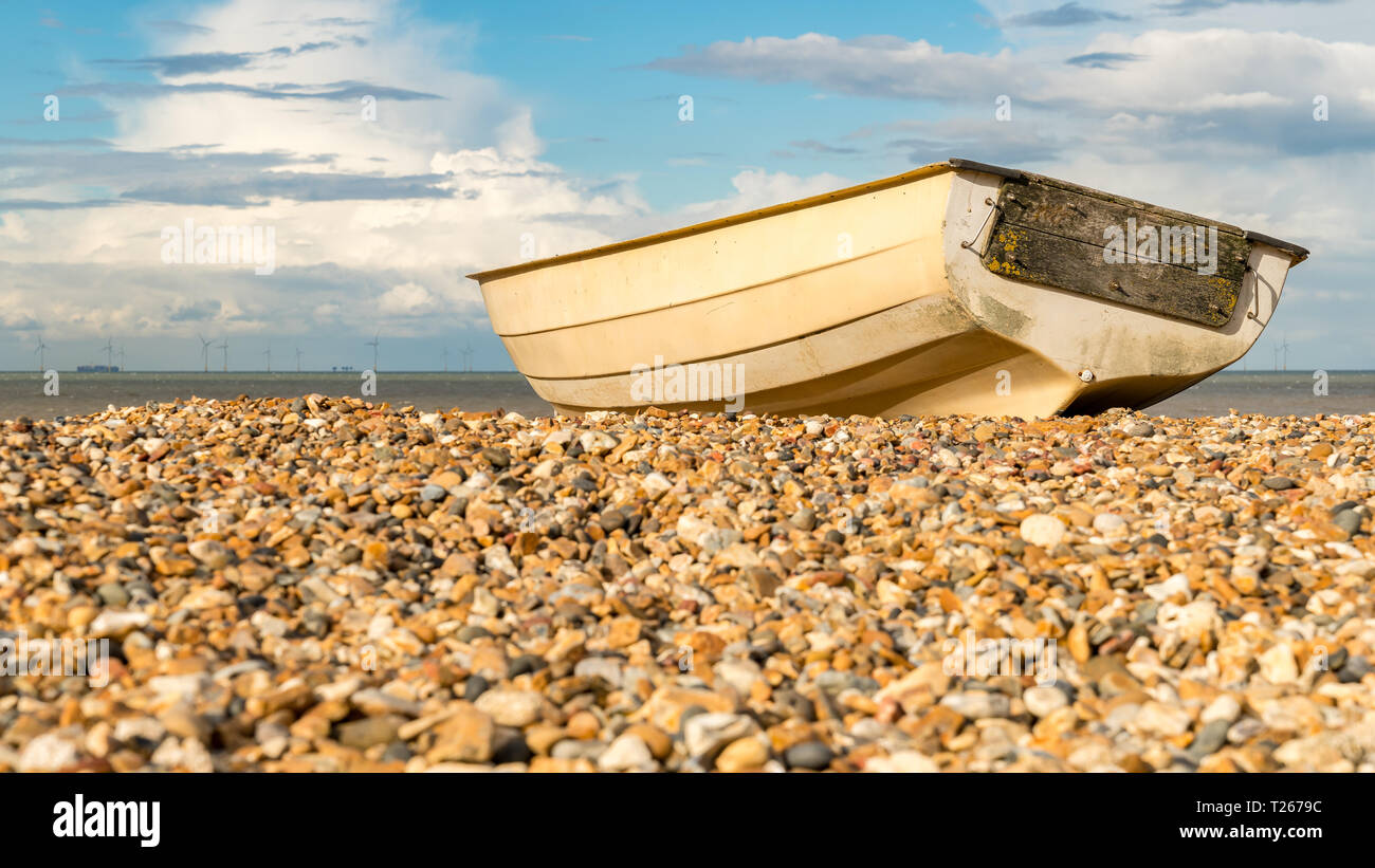 Clouds over a boat on the pebbles of Tankerton beach in Whitstable ...