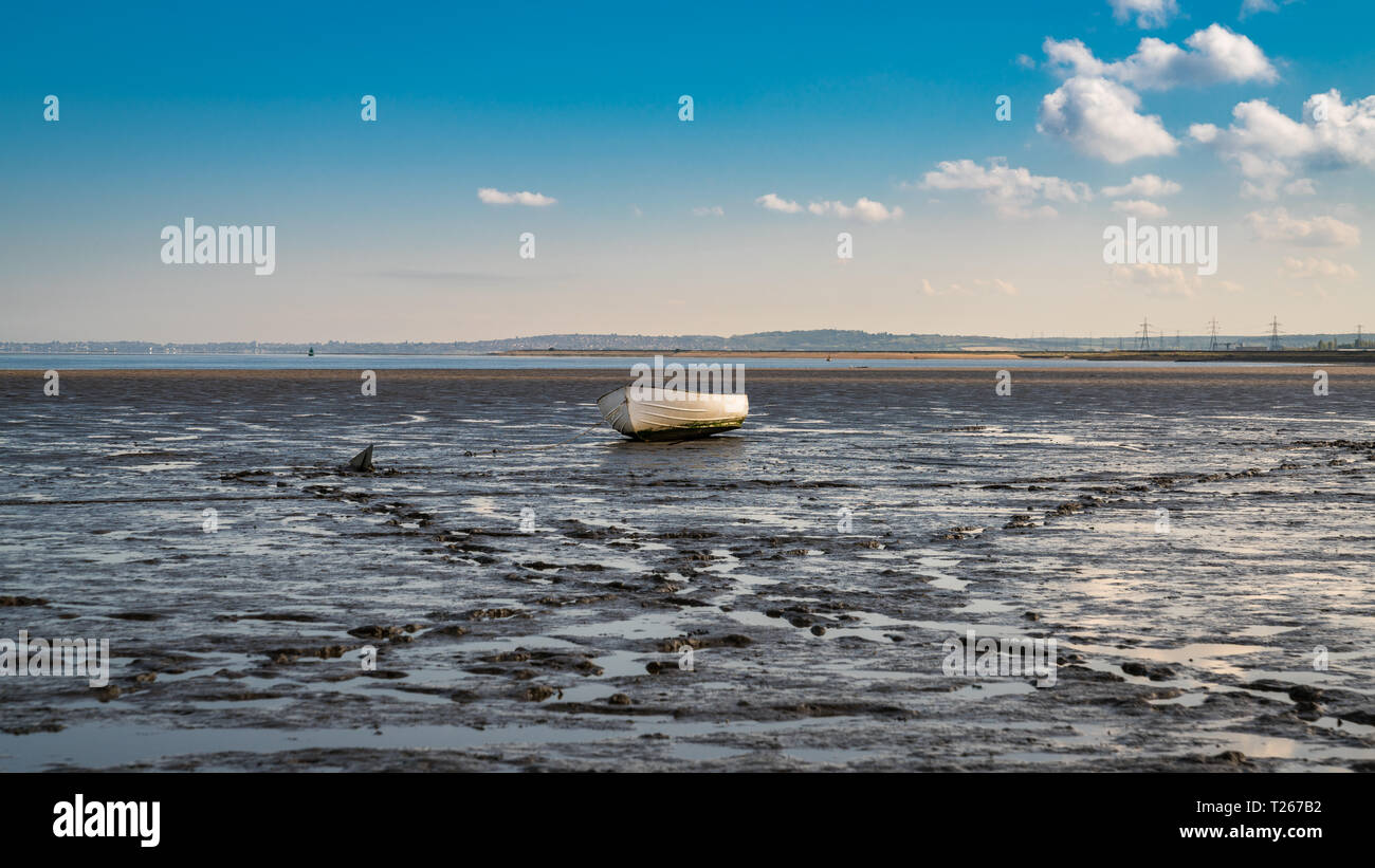 A boat in the Oare Marshes with the North Sea coast of Kent in the ...
