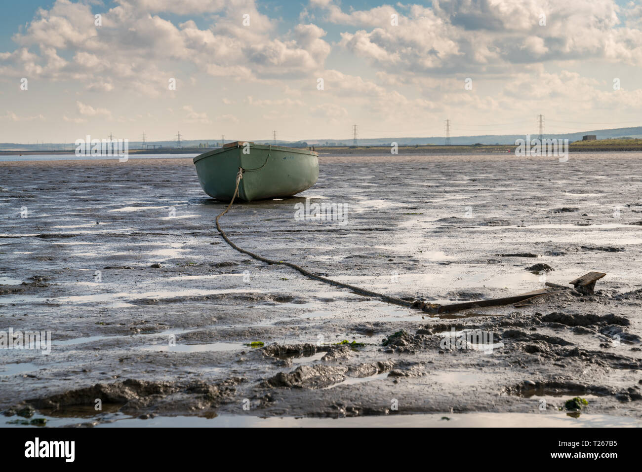 A boat in the Oare Marshes with the North Sea coast of Kent in the ...