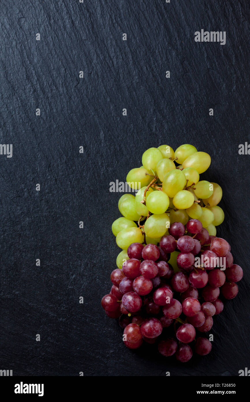 Blue and green grapes on black slate slab Stock Photo - Alamy