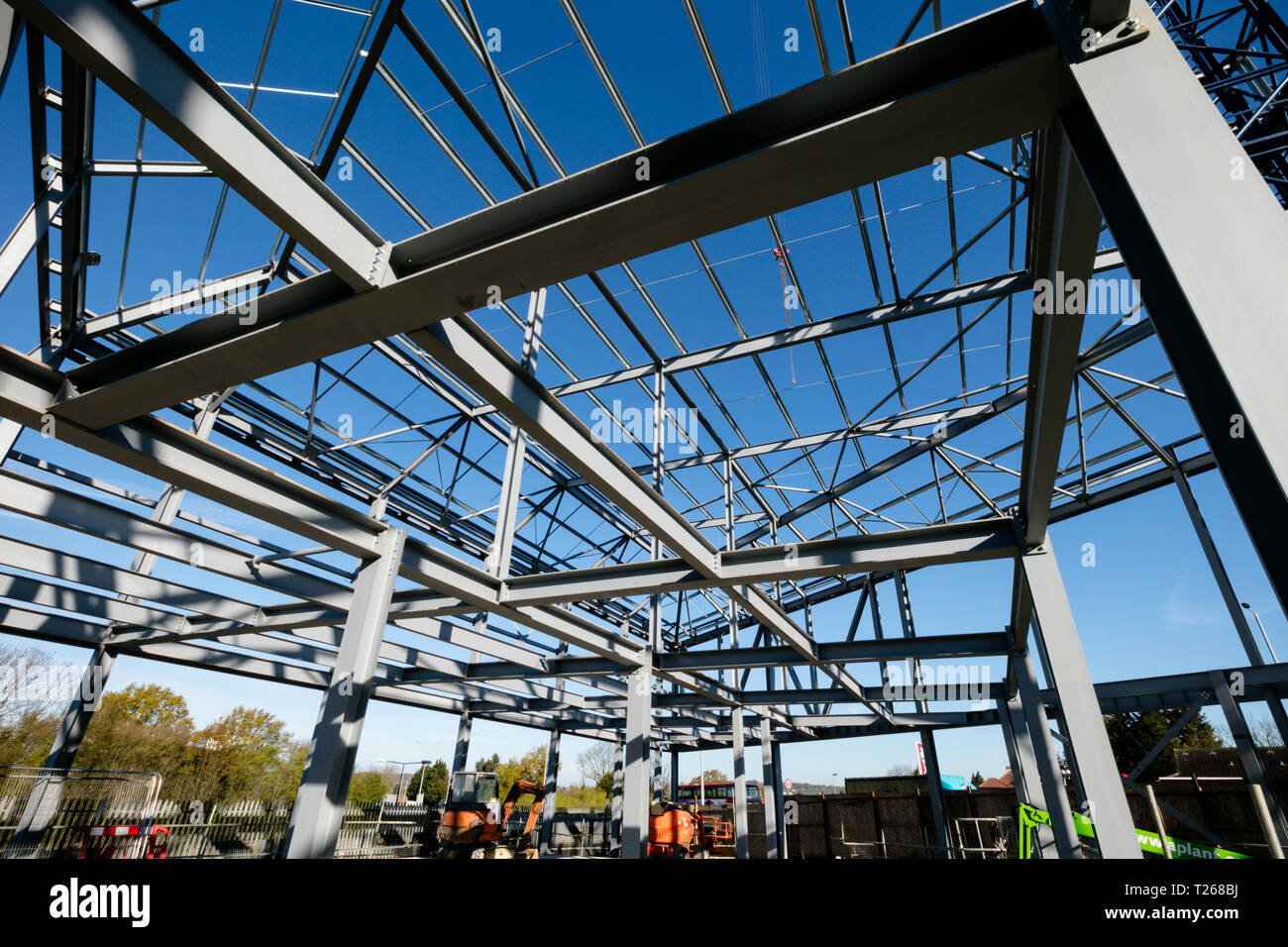 Steel frame of new building in construction set against bright blue sky ...