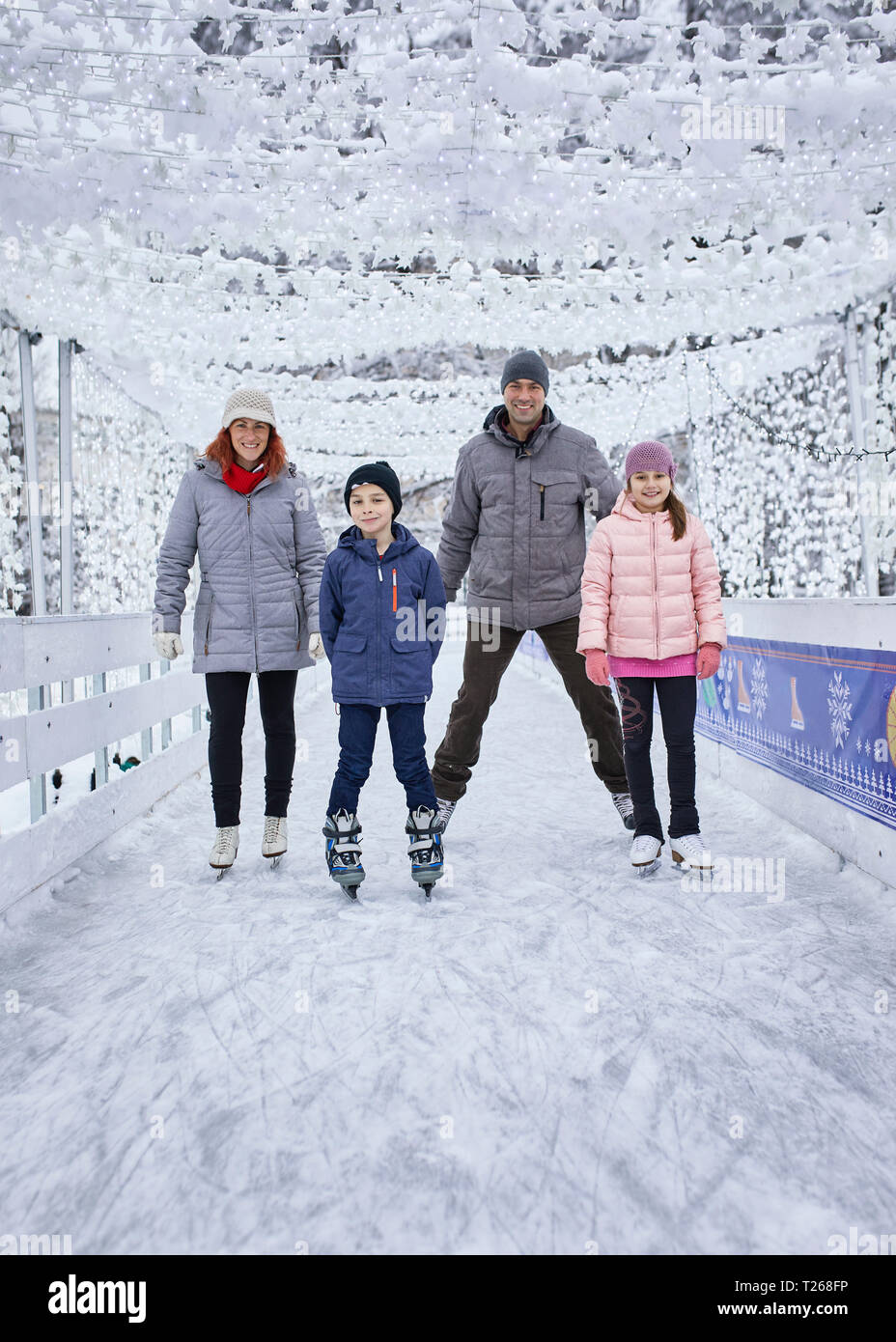 Family with two kids ice skating on the ice rink Stock Photo - Alamy