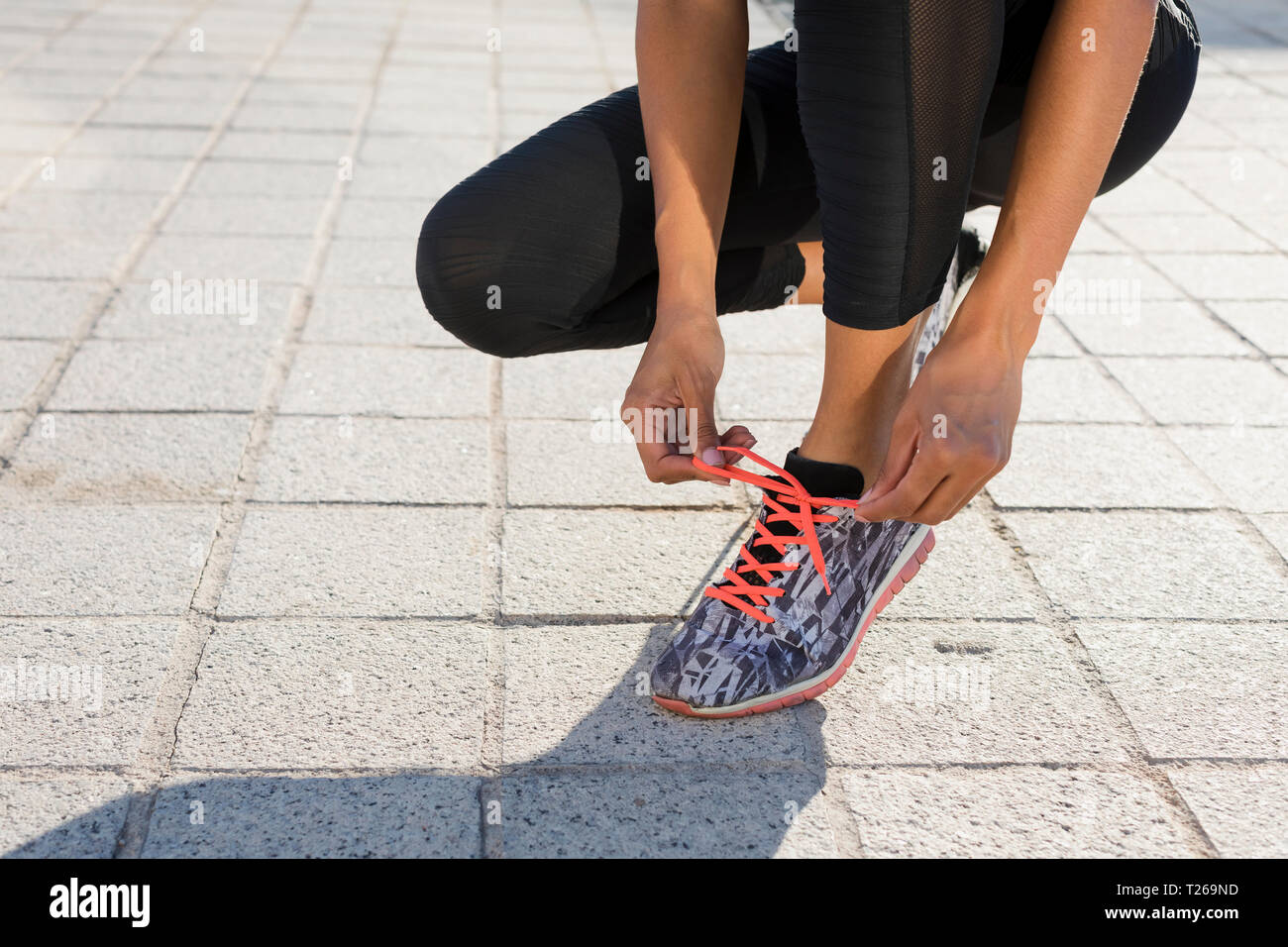 Woman tying her shoes hi-res stock photography and images - Alamy