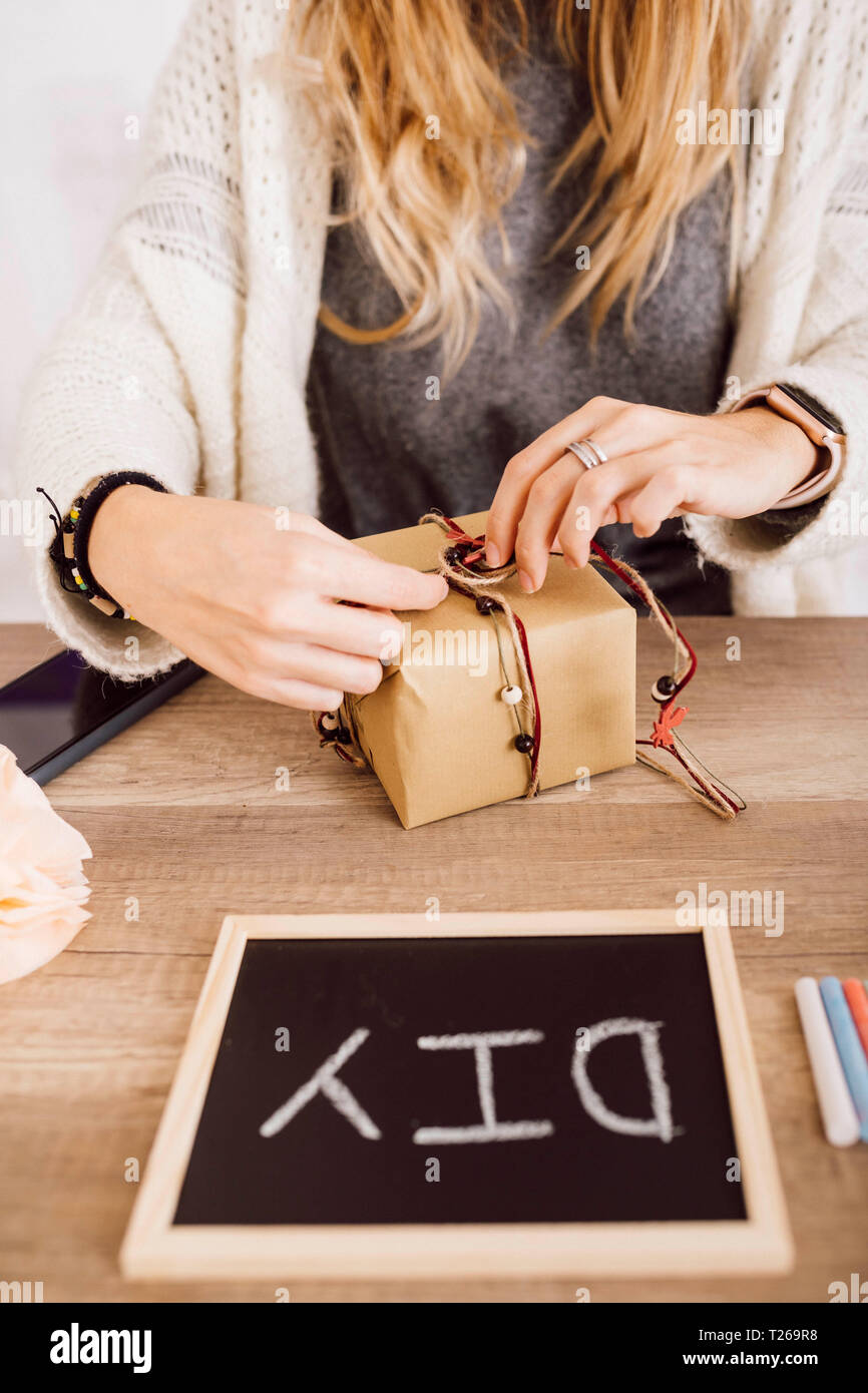 Young woman wrapping a gift in her studio Stock Photo - Alamy