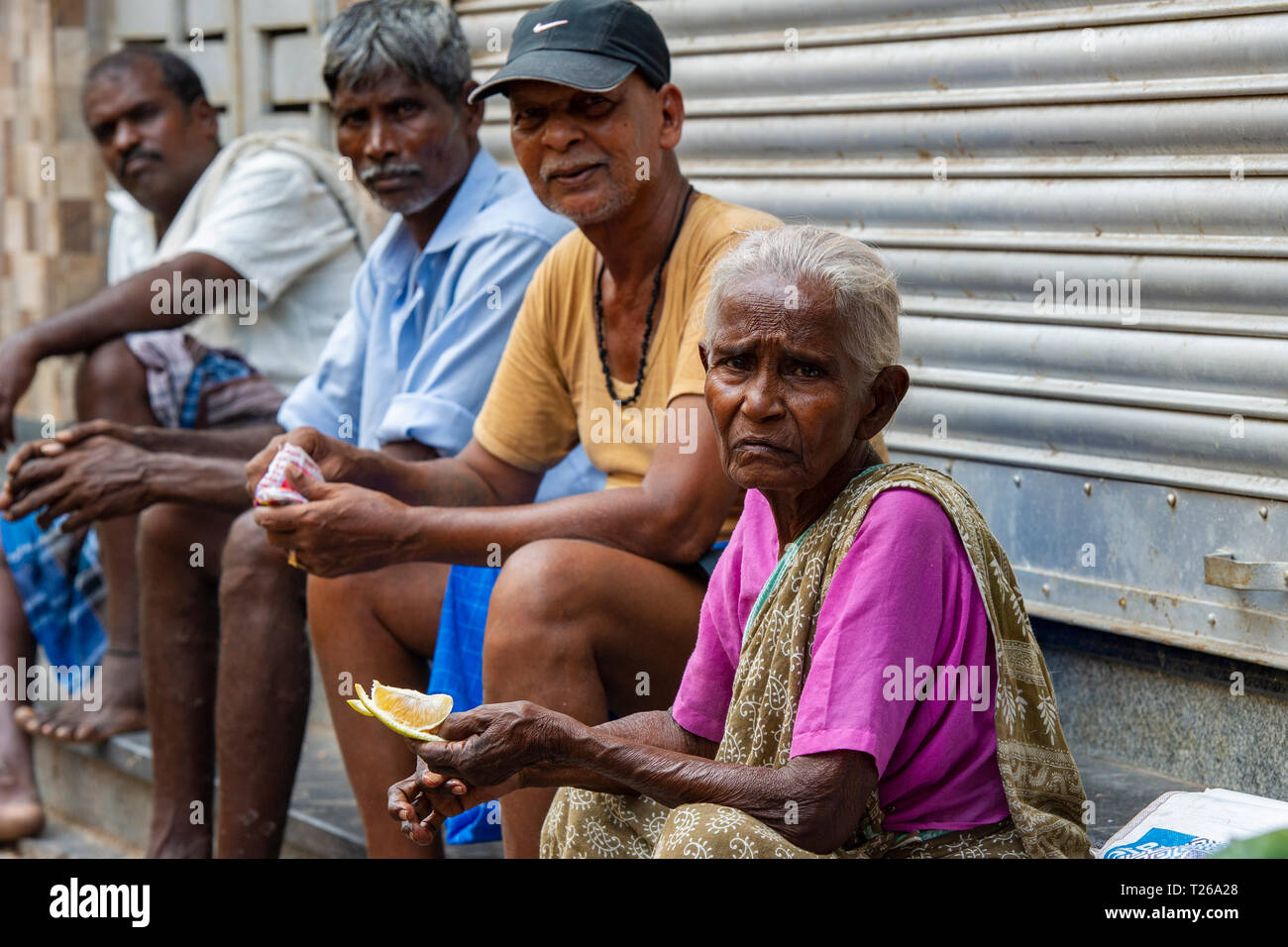 Four people look straight into camera in a run down area of Chennai ...