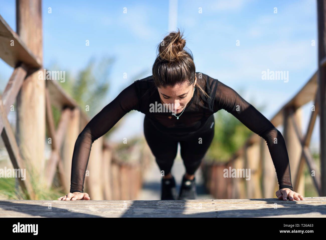 Sportive woman doing push-ups on wooden bridge Stock Photo - Alamy