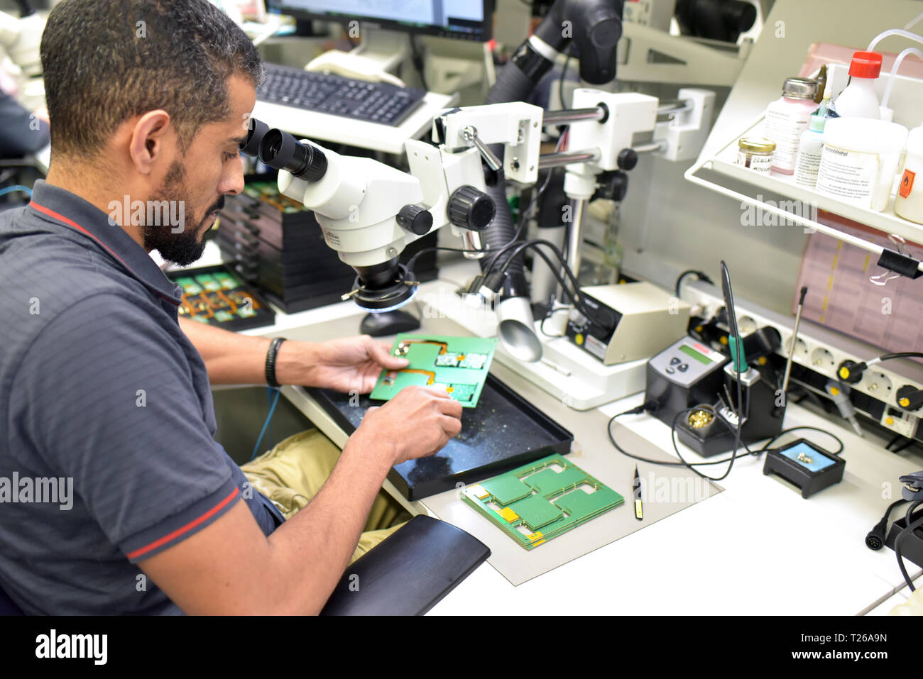 Man using a microscope for the quality control in the manufacturing of ...
