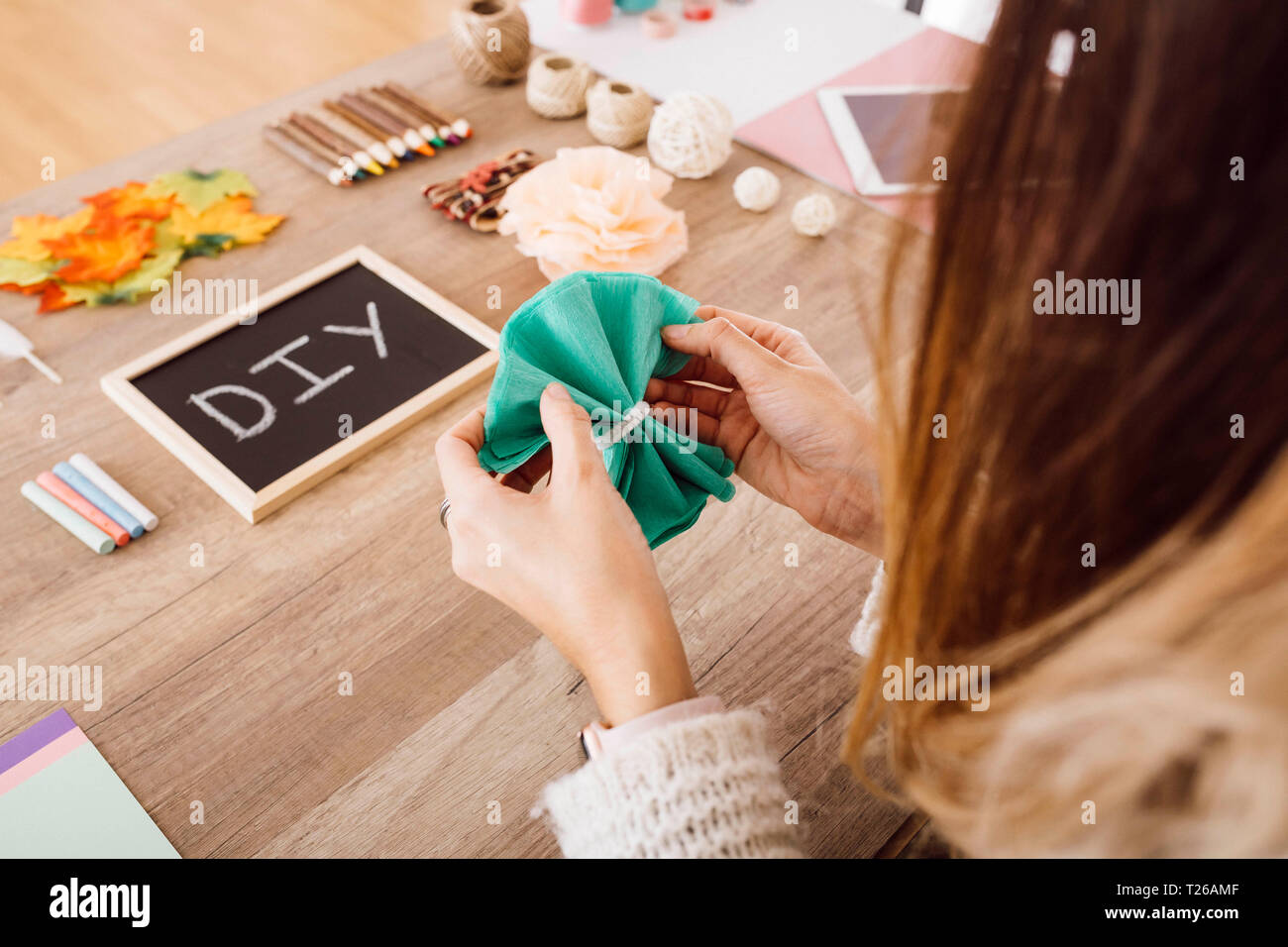 Young woman doing crafts with paper flowers in her studio Stock Photo ...