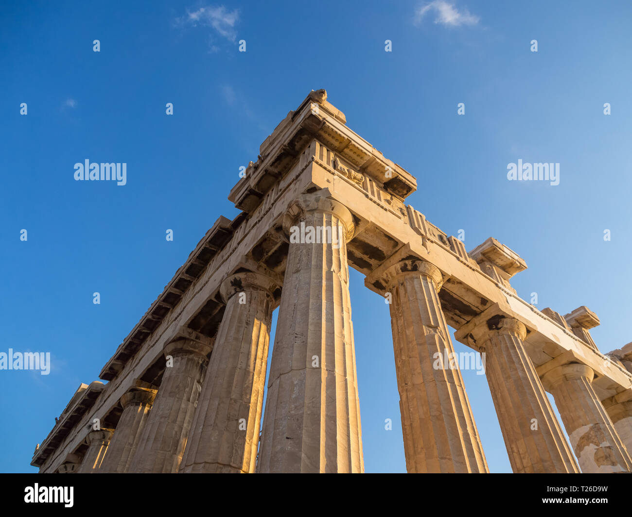 View of corner of Parthenon and its columns on Acropolis in Athens, Greece against blue sky ...
