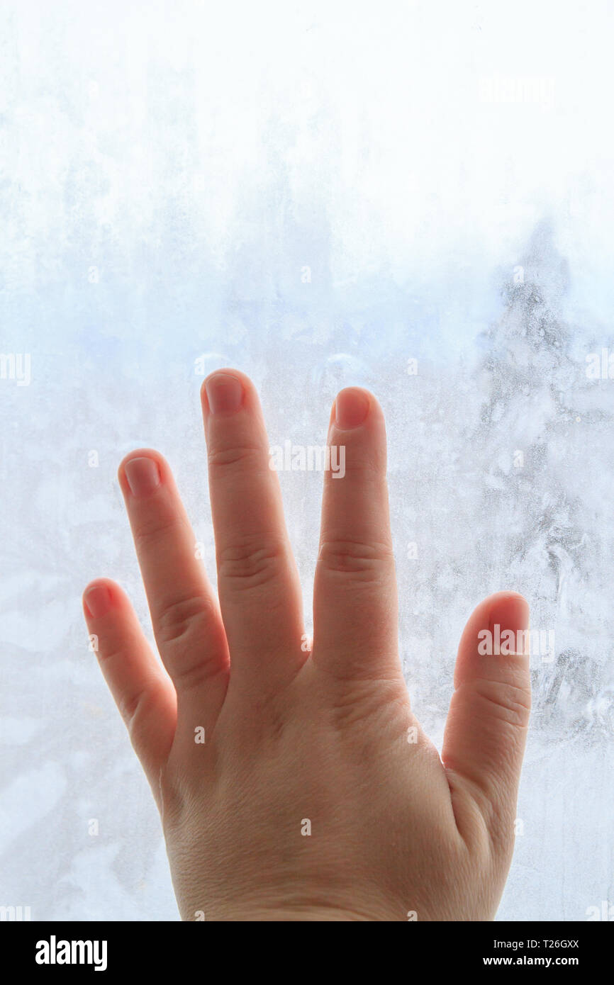 Hand on frozen winter cold window with patterns Stock Photo - Alamy