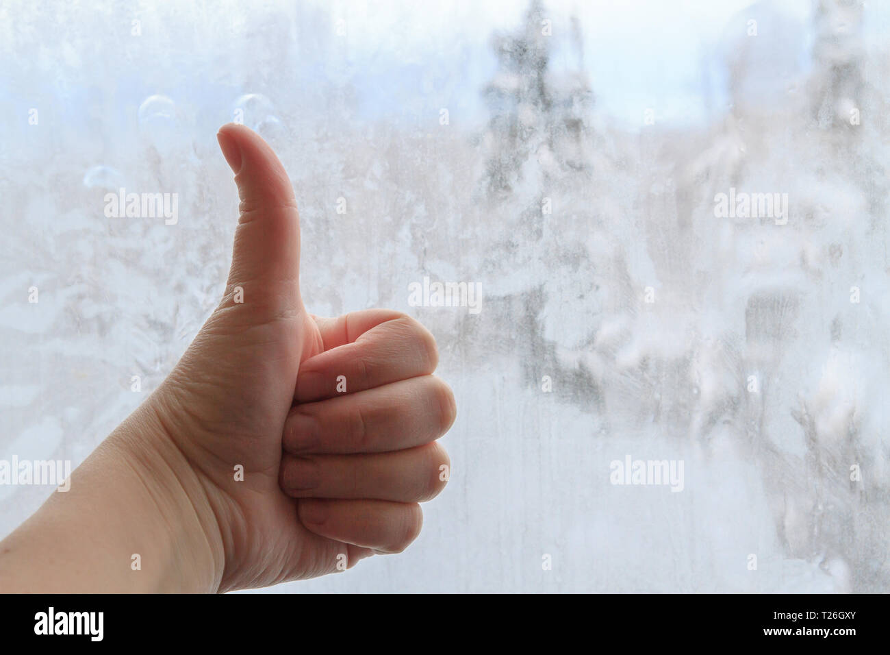 Sign of thumb up hand in front of a frozen window Stock Photo - Alamy