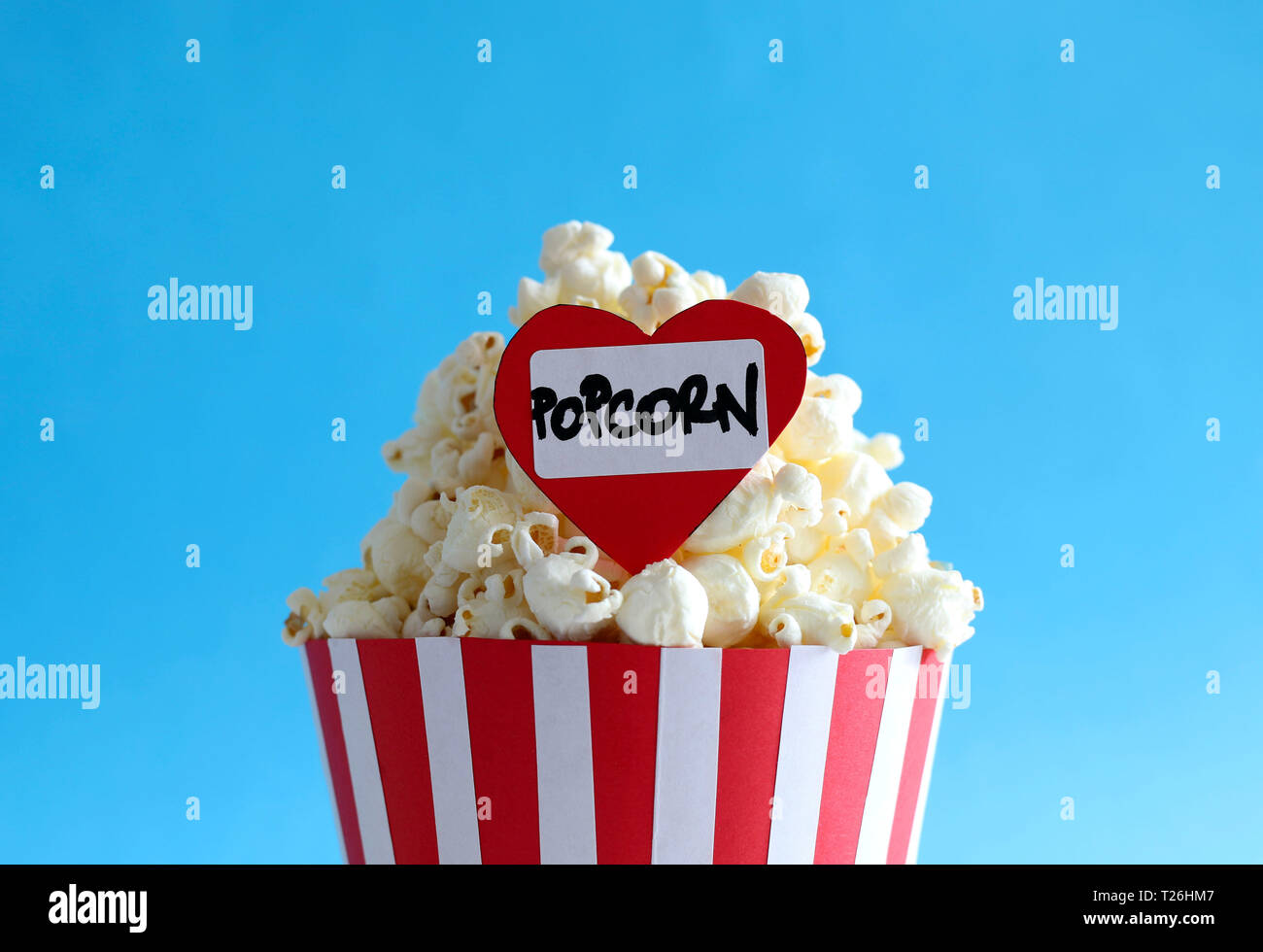 Delicious popcorn in classic red and white paper striped bag with label ...