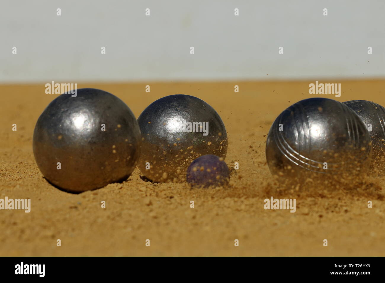 A French boule captured at the moment of impact causing a small ...