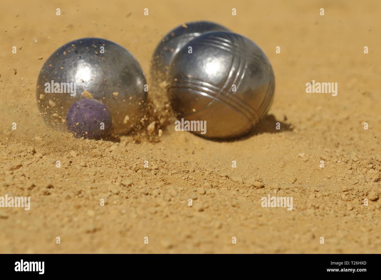 A French boule captured at the moment of impact causing a small ...