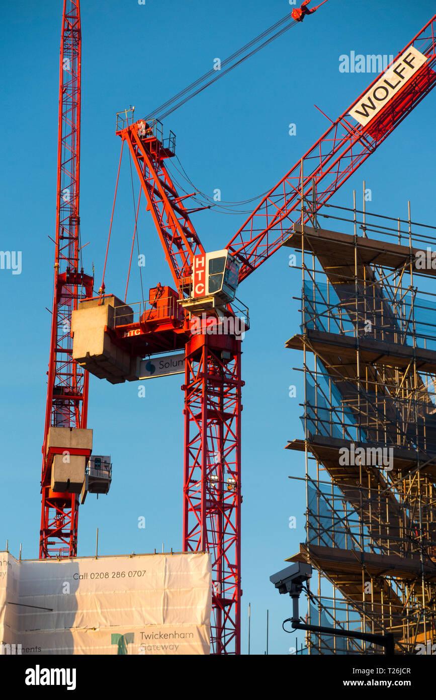 Construction site with 2 / two luffing jib tower cranes at work ...