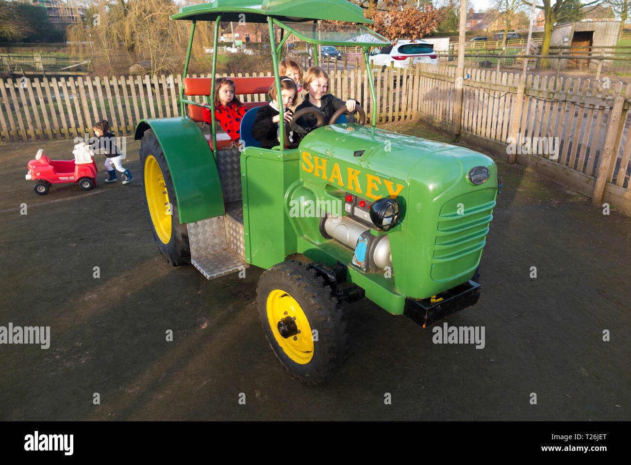 Kids / children / child on a life size model toy tractor of large scale ...