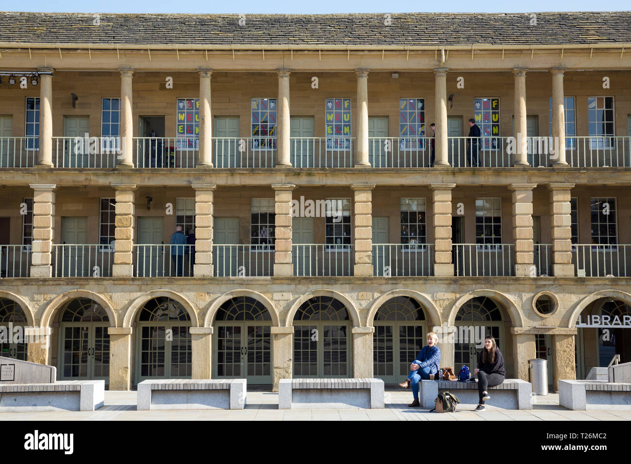 Women sitting on a bench in front of the east wall colonnade ...