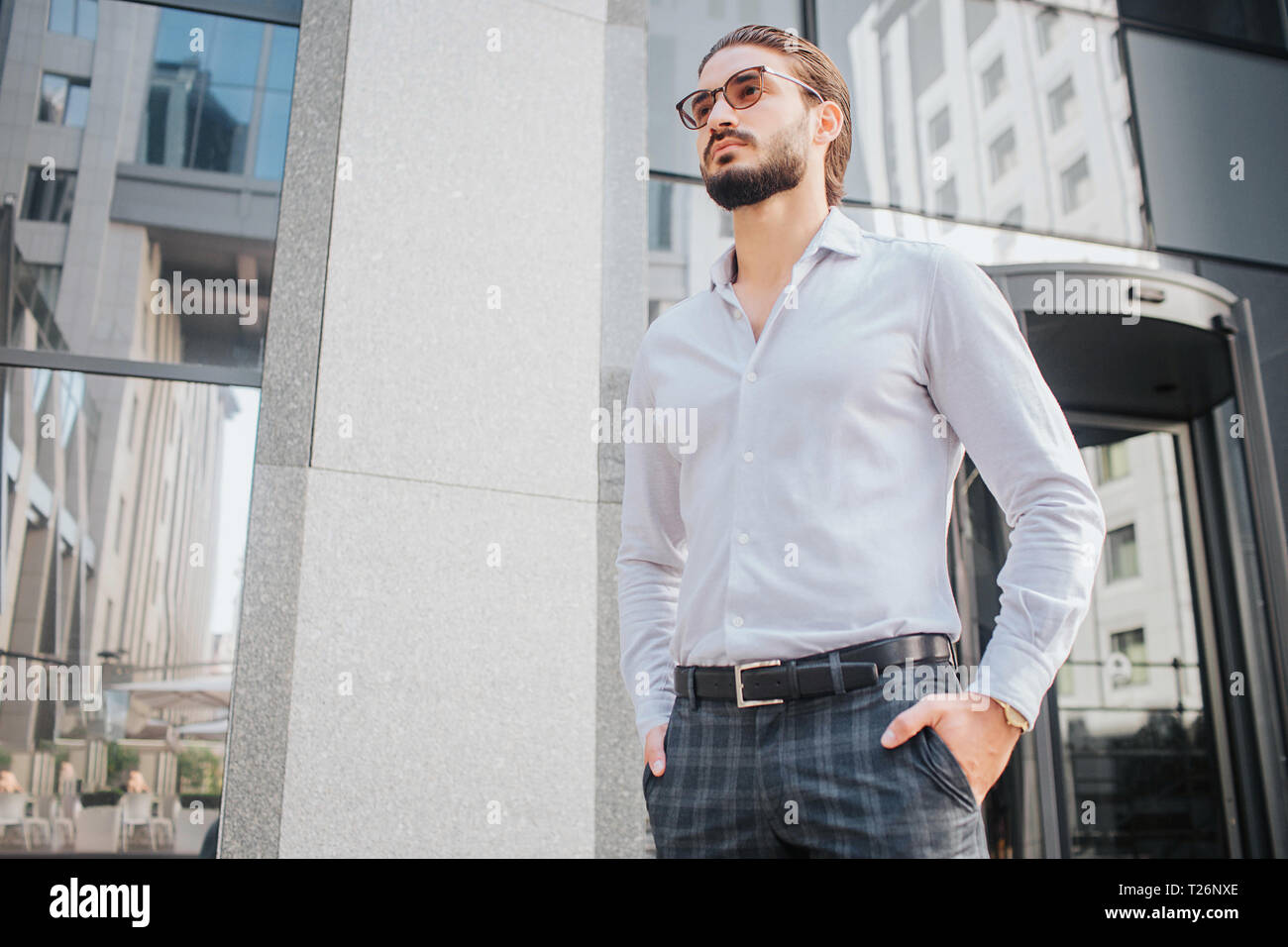 Beautiful male model stands and poses. He looks stylish. Young man ...