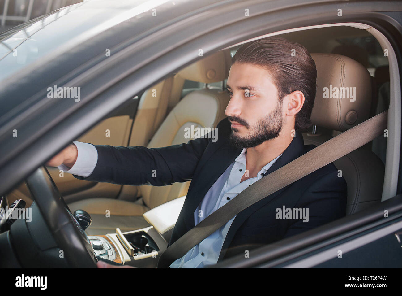 Picture of nice and confident businessman sitting in luxury car. He ...