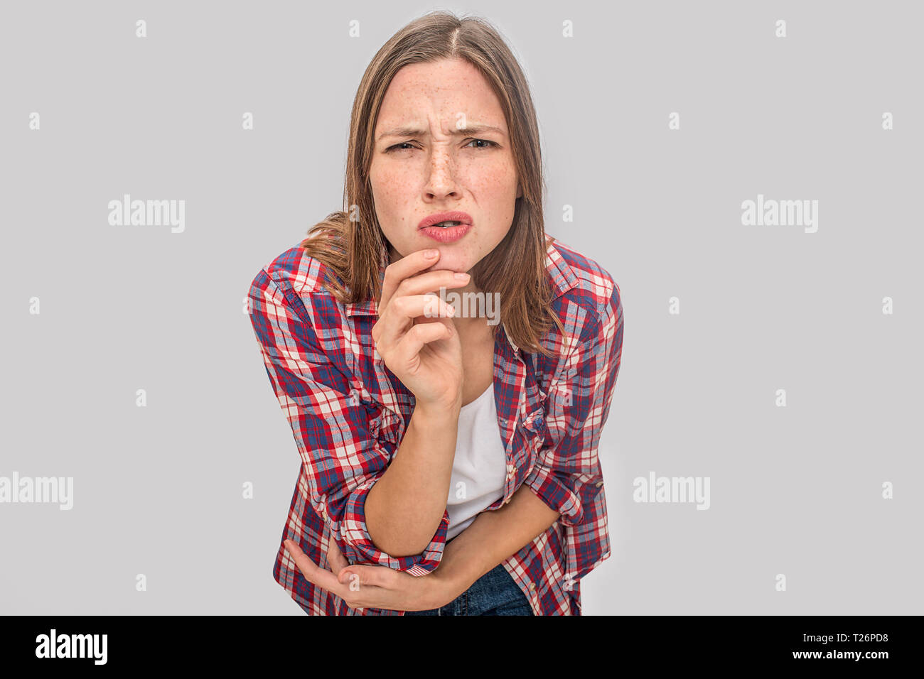 Suspicious Young Woman Stands And Looks Closer To Camera She Holds