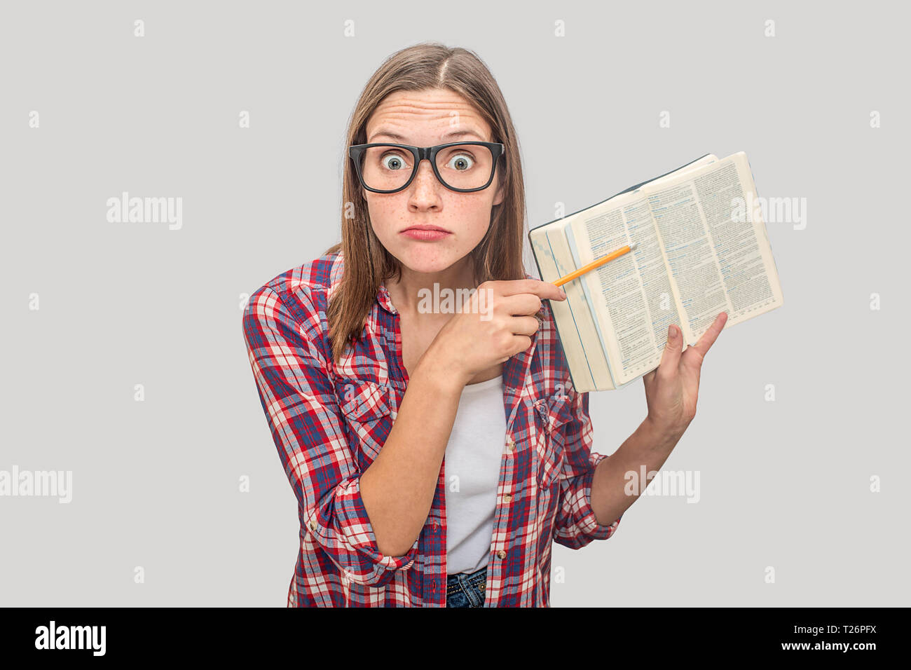 Weird and strange female geek keeps book wide opened and shows its ...