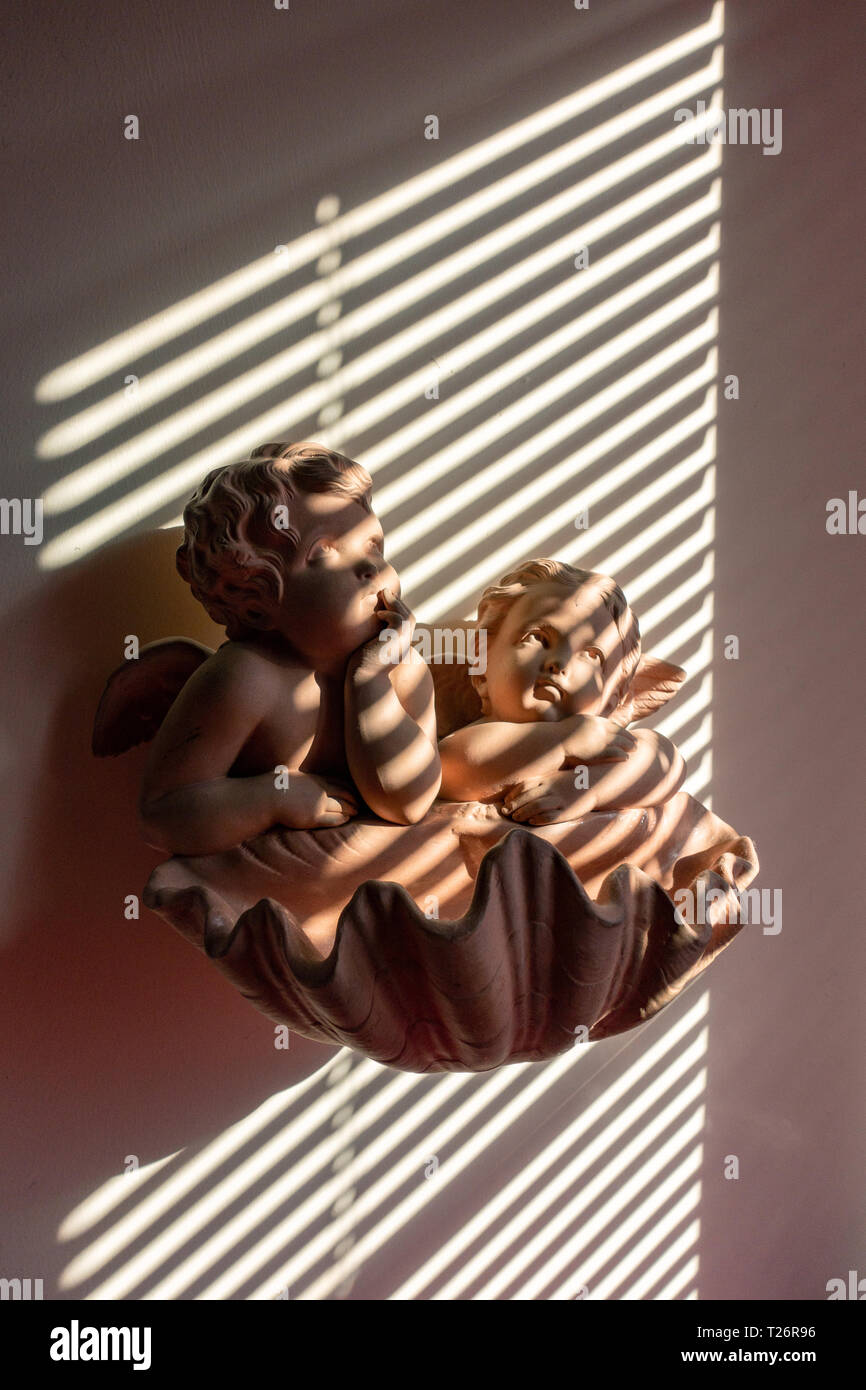 Two pretty Cherubs leaning on their arms and looking out as they lean ...