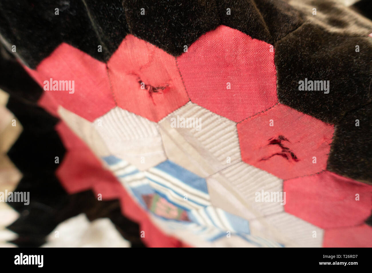 closeup of Damaged and ripped material on a 1970's hand sewn patchwork ...