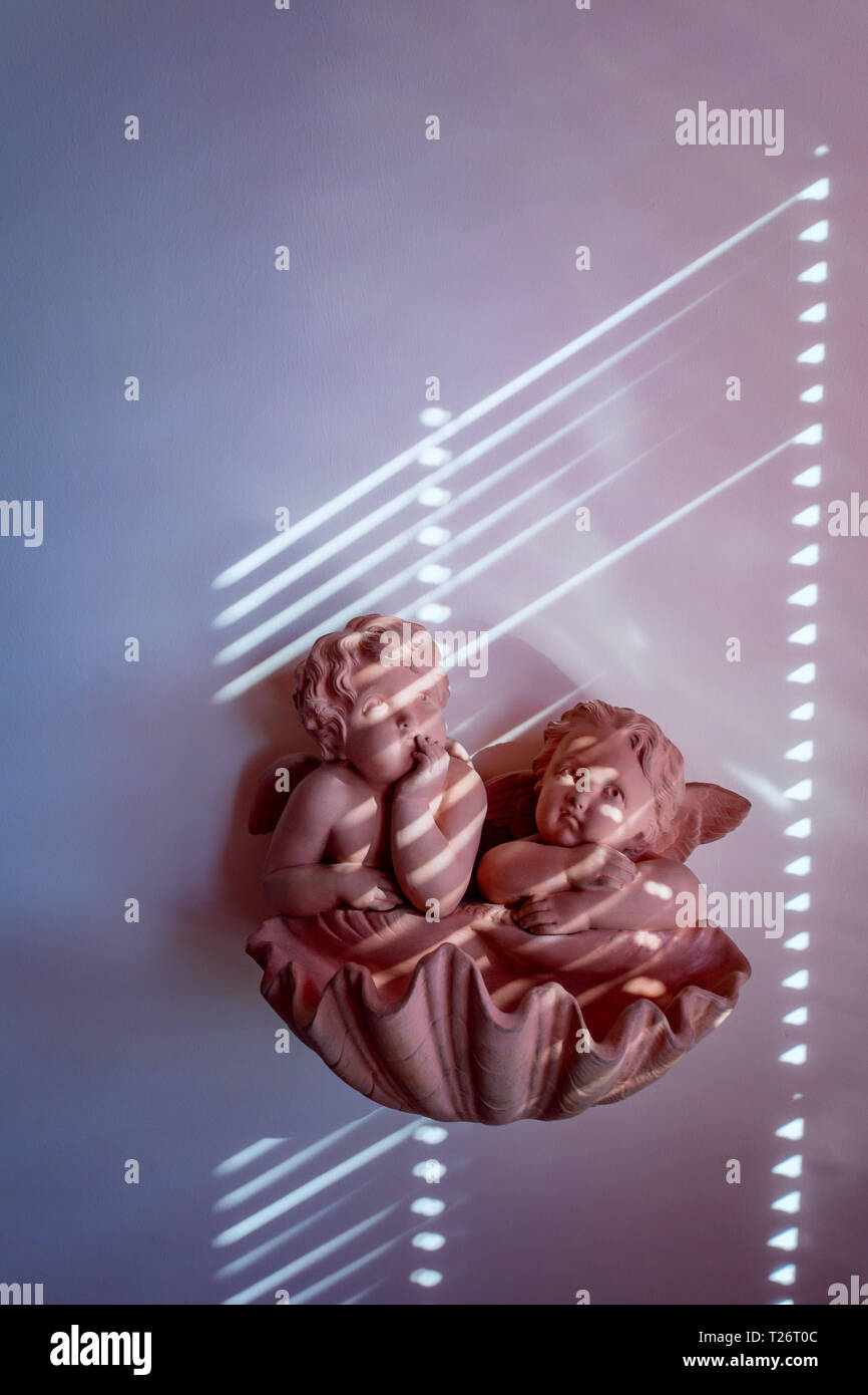 Two pretty Cherubs leaning on their arms and looking out as they lean ...