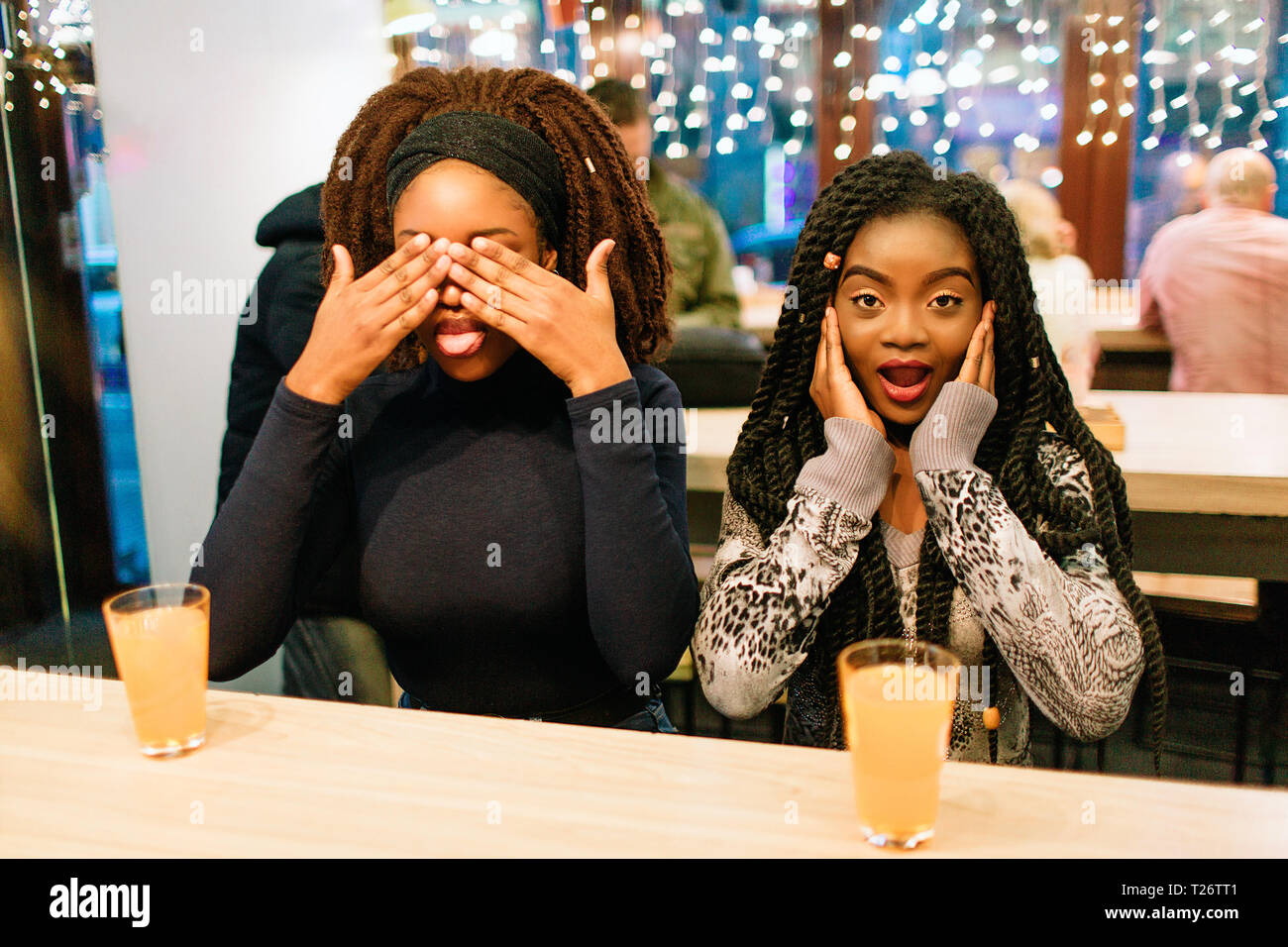 Cheerful nice young african women sit at table and have fun. First ...