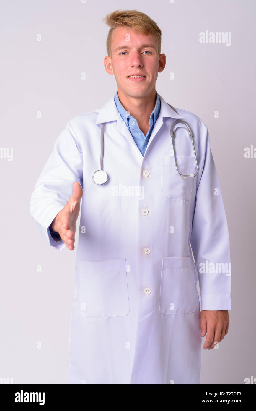 Portrait of happy young blonde man doctor giving handshake Stock Photo ...