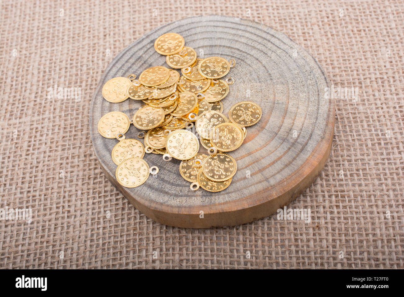 Plenty of fake gold coins are on a piece of wood Stock Photo - Alamy