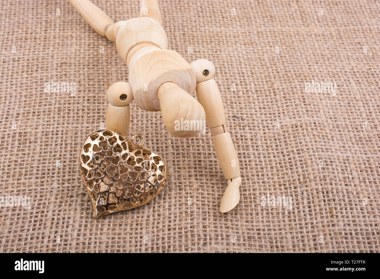 Heart shaped object in the hand of a wooden man toy Stock Photo - Alamy