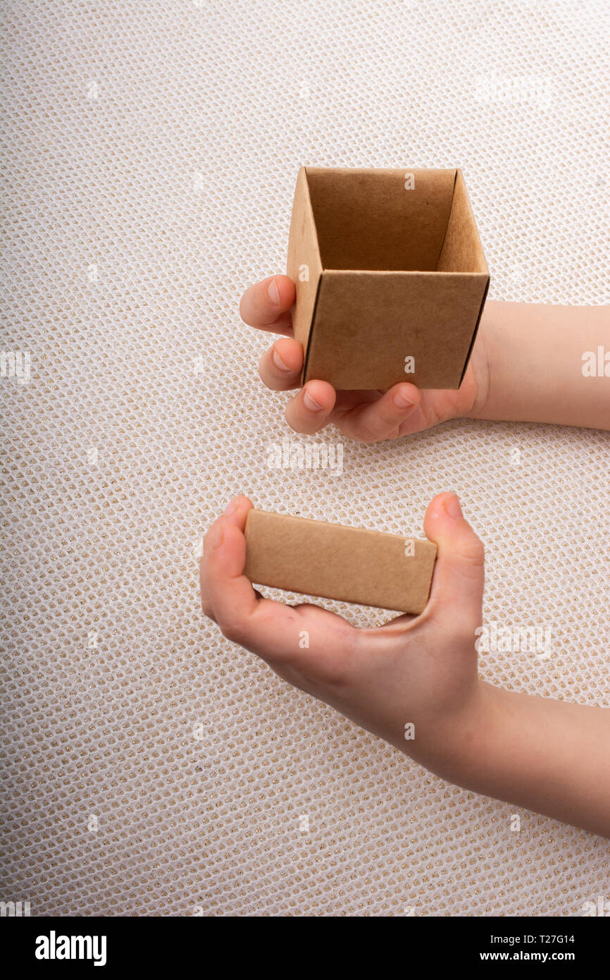 Hand holding a brown cardboard box on white backgrounds Stock Photo - Alamy