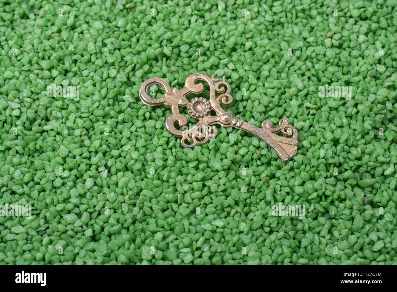 Retro style gold color key on green sand Stock Photo - Alamy