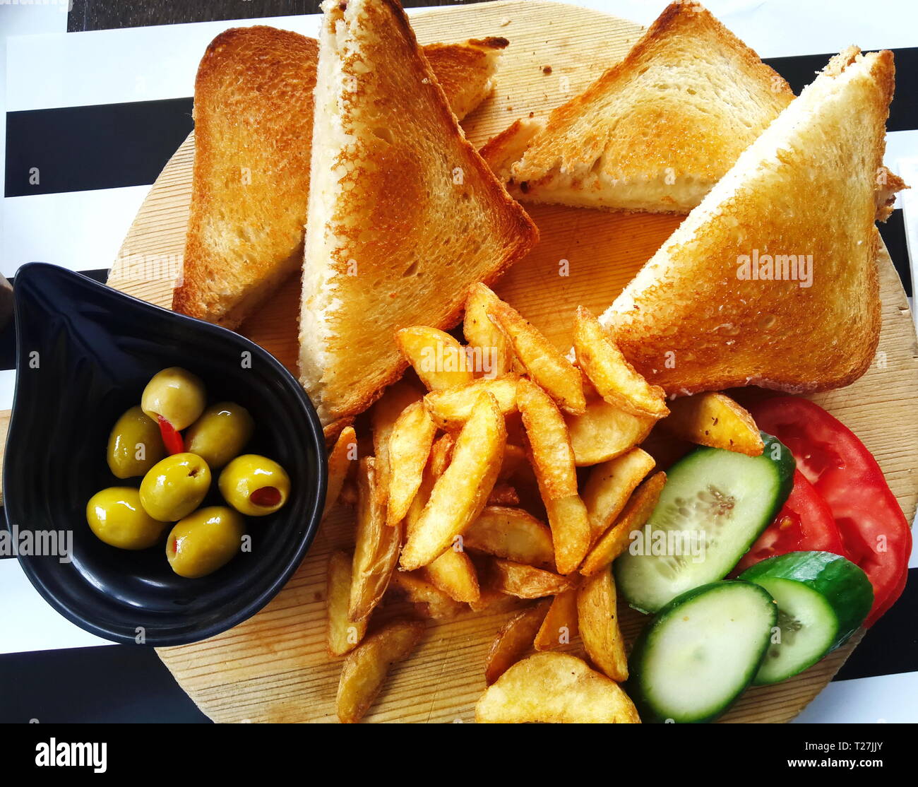 cheddar cheese fried toast. served with potato fries and olives Stock ...