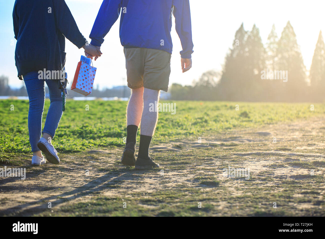 People walking through a park facing the sun, Spring season Stock Photo ...