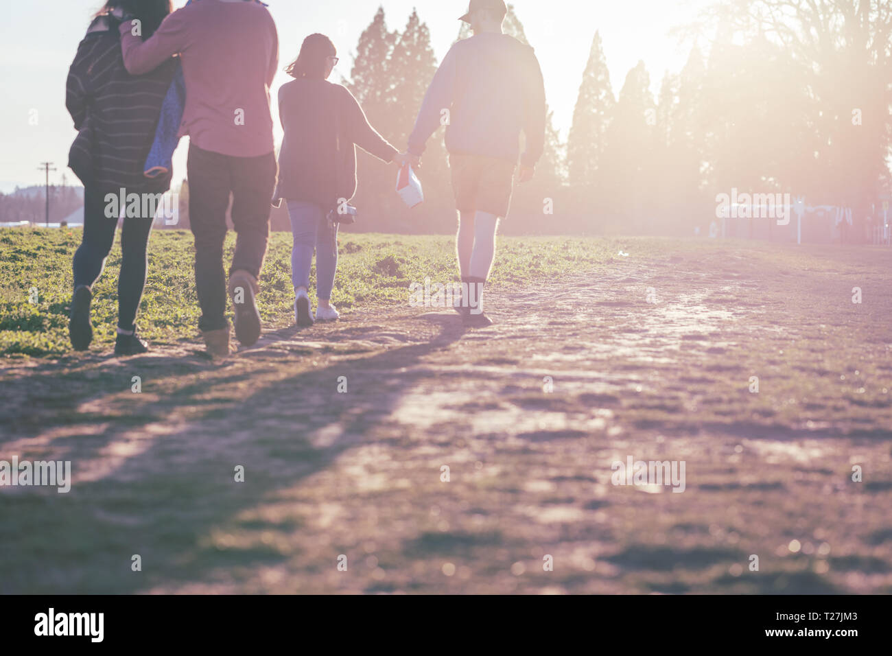 People walking through a park facing the sun, Spring season Stock Photo ...