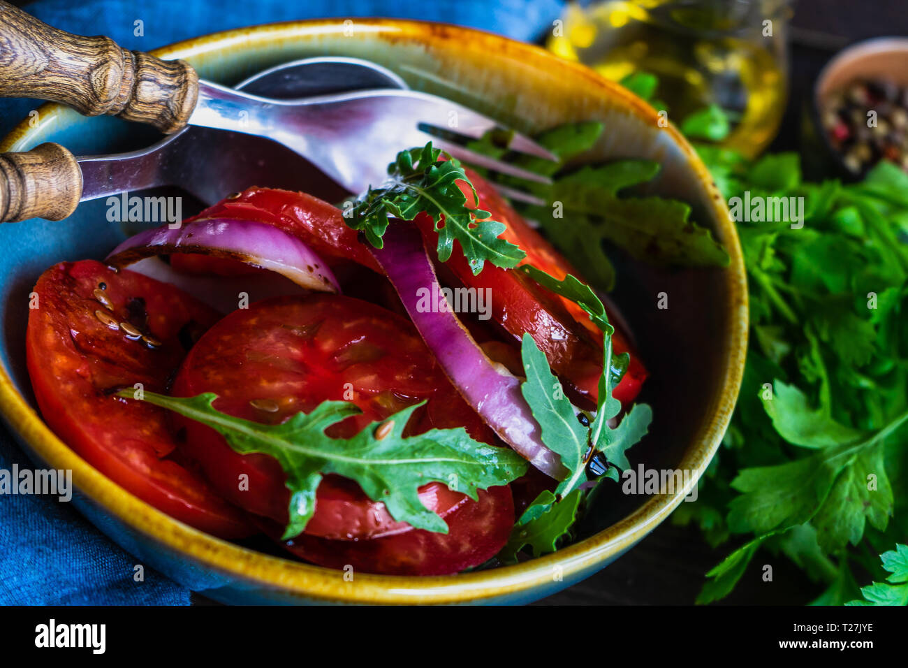 Ceramic bowl full of salad of organic vegetables like a tomato, red ...