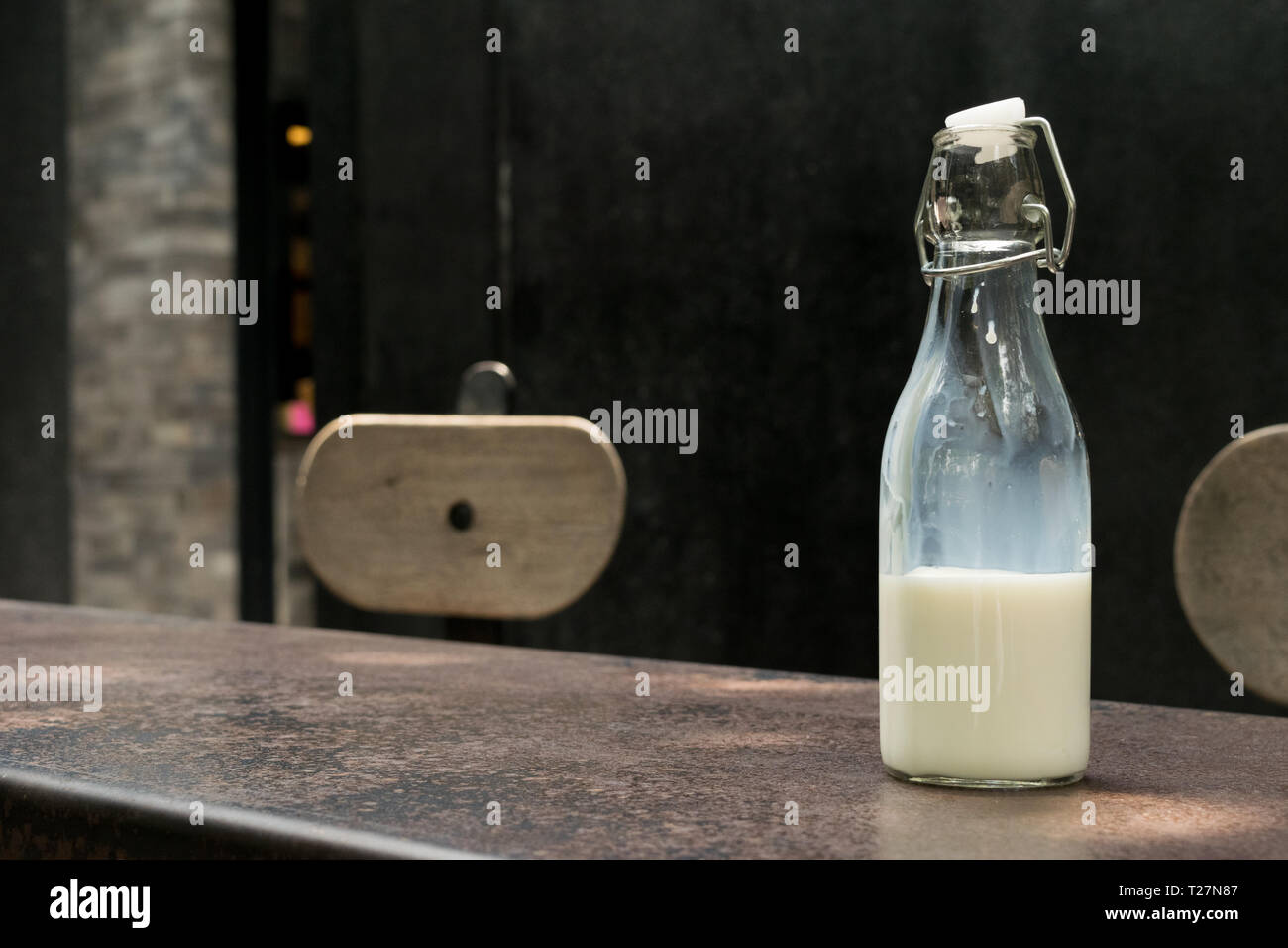 bottle of milk on table in front on black wall background Stock Photo ...