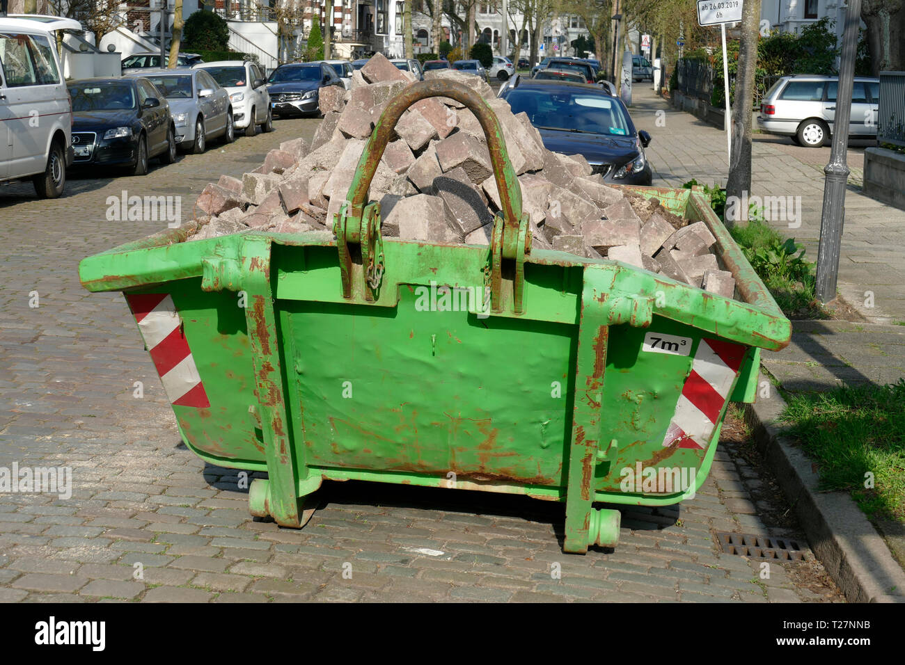 Old green sedimentation trough filled with rubble in a residential ...