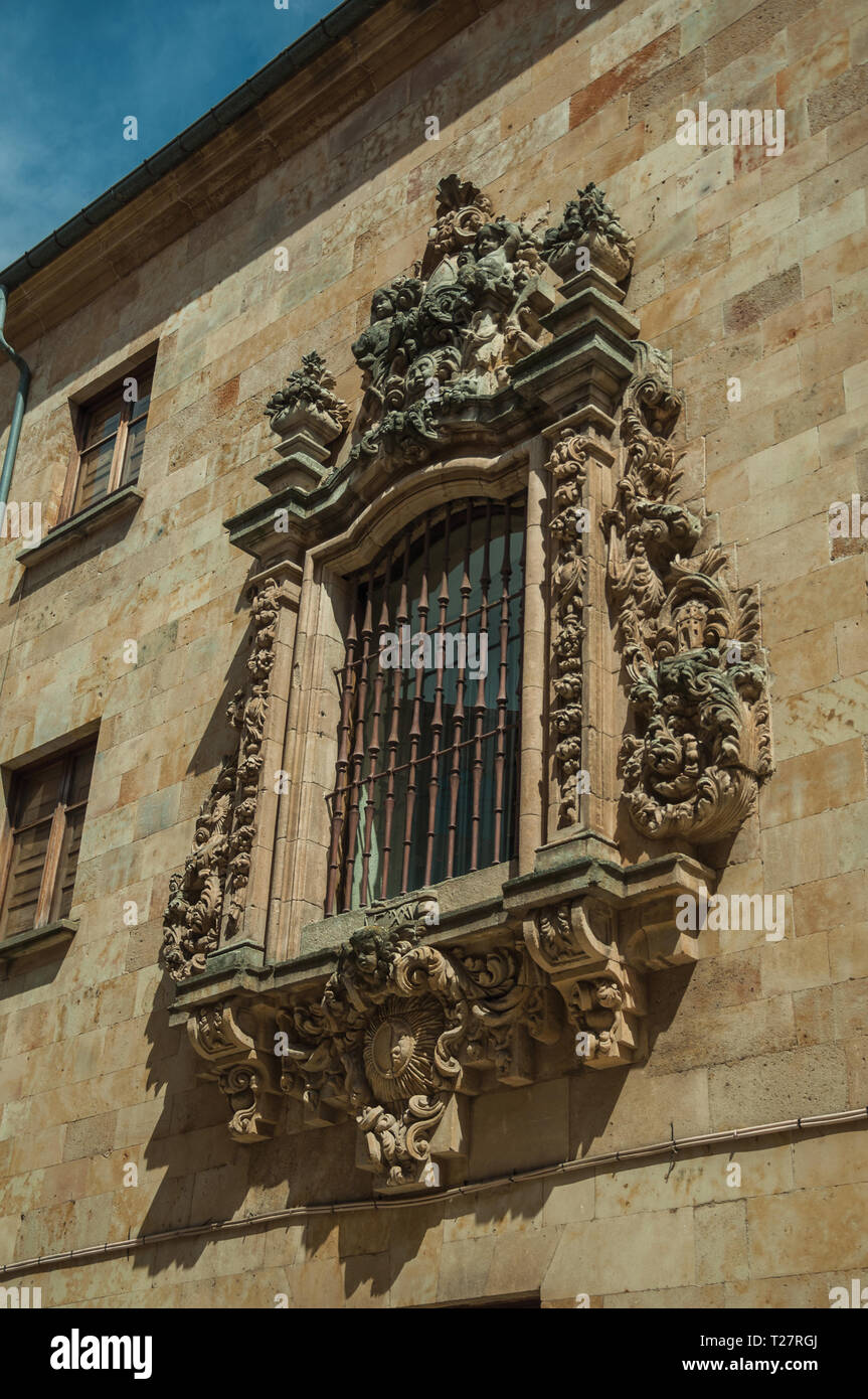 Window on stone wall of old building decorated by stone sculptures at ...