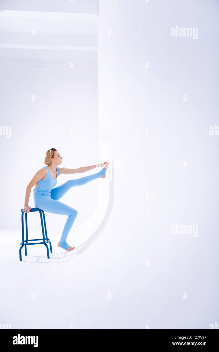 Attractive well built woman sitting near the wall Stock Photo - Alamy