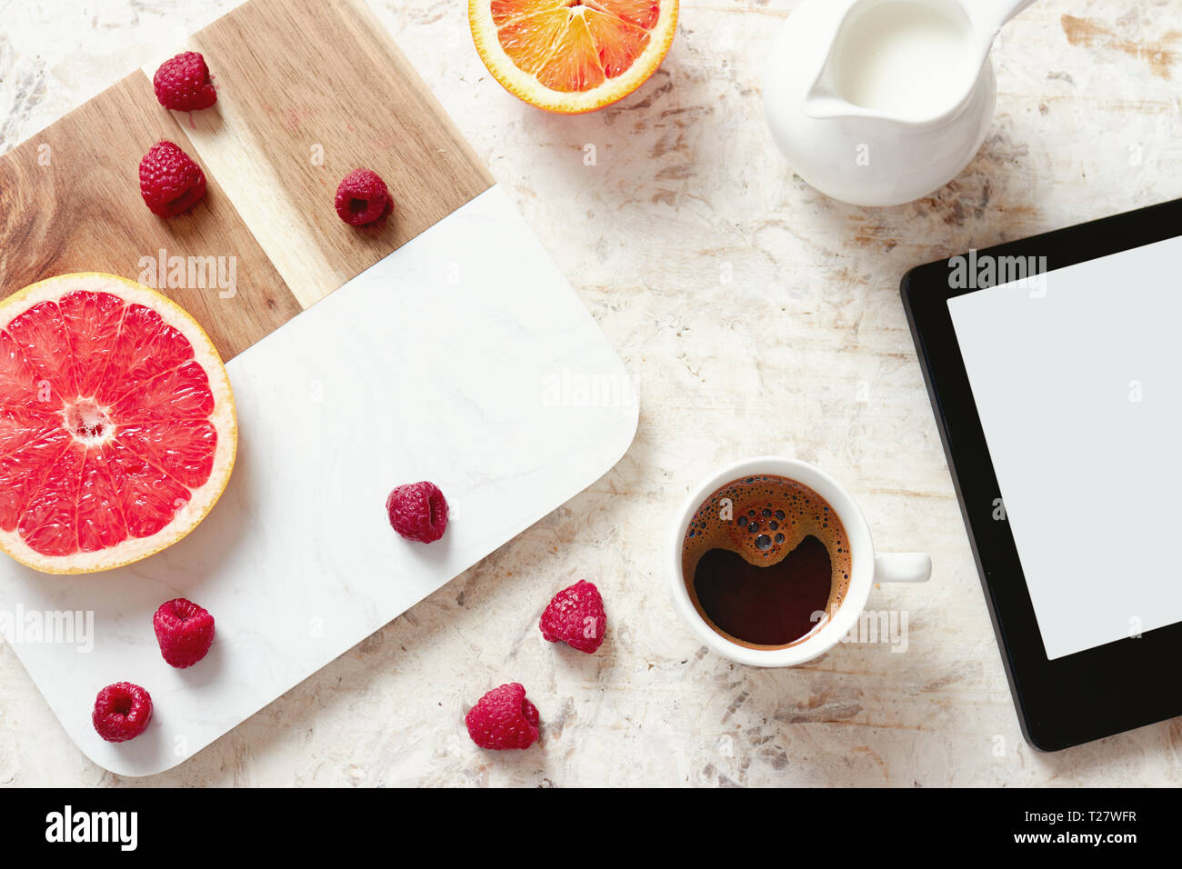 Breakfast table with coffee, various fresh fruits and tablet Stock ...