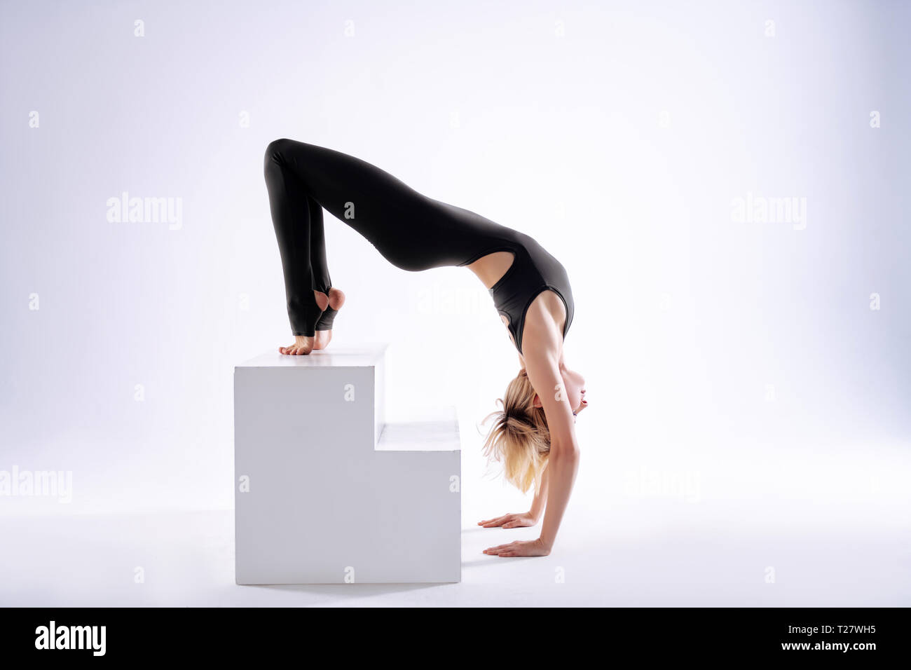 Nice skilled young gymnast doing a backbend Stock Photo - Alamy
