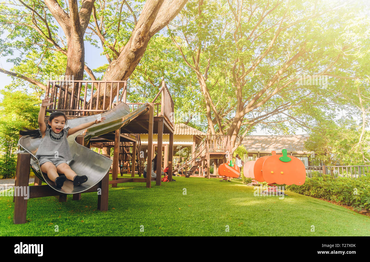 Asian kid playing slide at the playground Stock Photo - Alamy