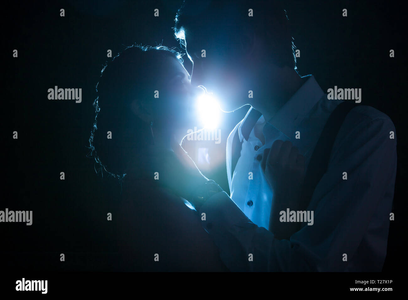 Romantic couple backlit with a blue light from behind. Studio photo ...