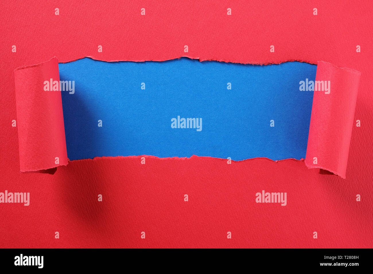 Torn red paper strip curled edge revealing center blue background Stock ...
